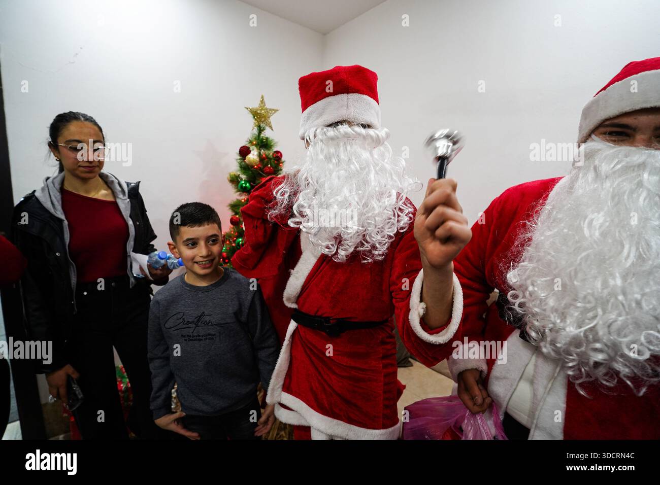 Syrian Orthodox refugees seen dressed as Santa Claus distribute gifts ...
