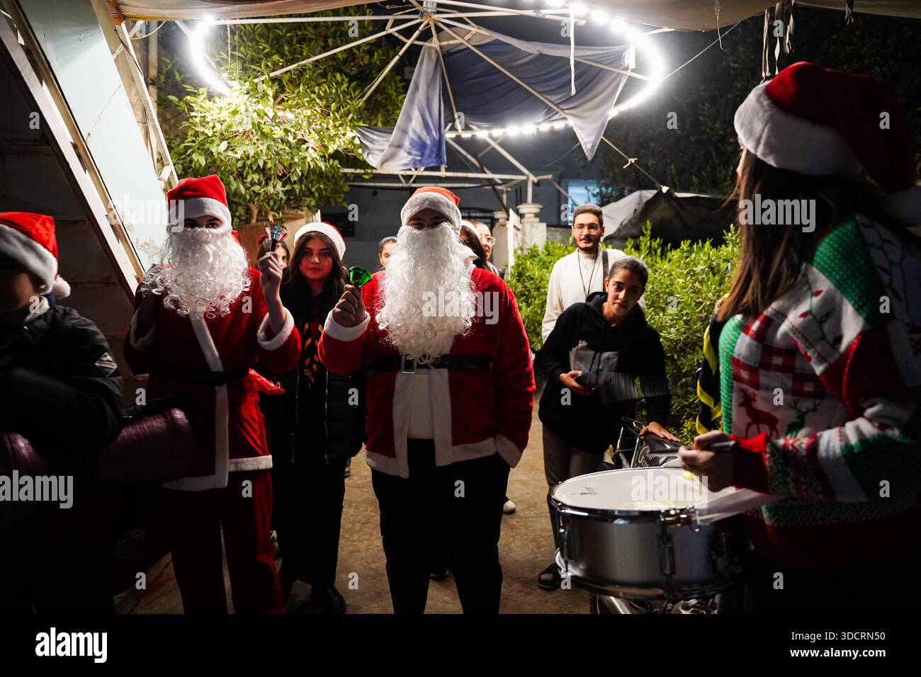 Syrian Orthodox refugees seen dressed as Santa Claus distribute gifts ...