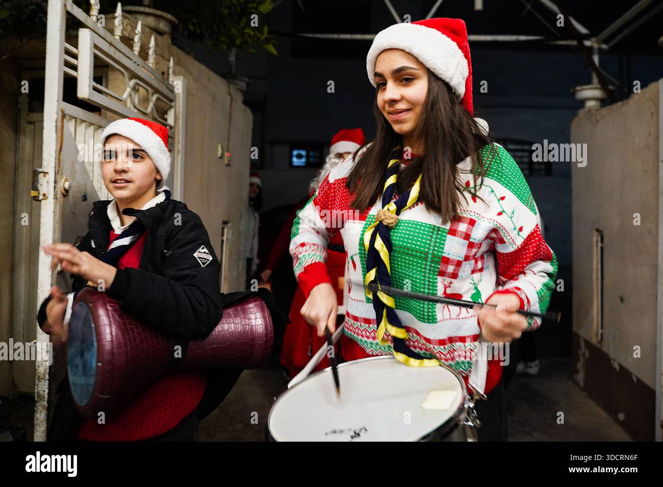 A Syrian Orthodox refugee seen dressed as Santa Claus beats the drum ...