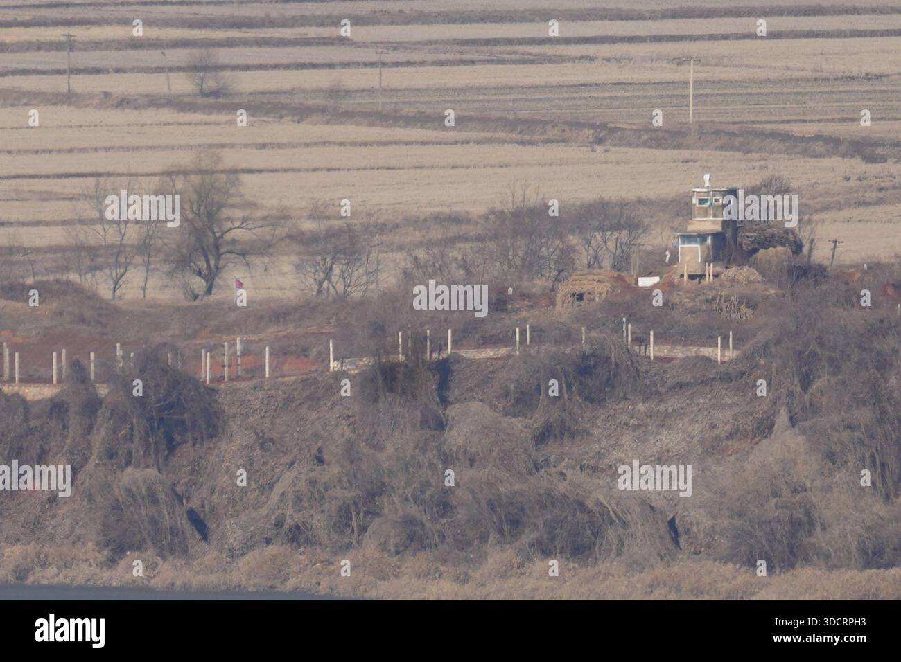 A North Korean flag flutters, left, near a military guard post in North ...