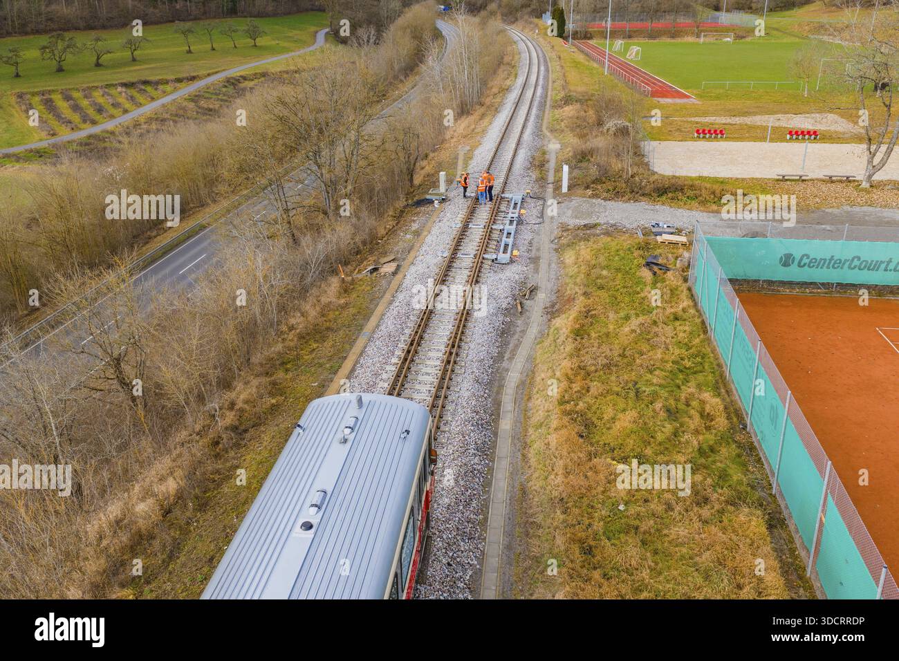Aerial view of railway tracks next to a sports field with a passing ...