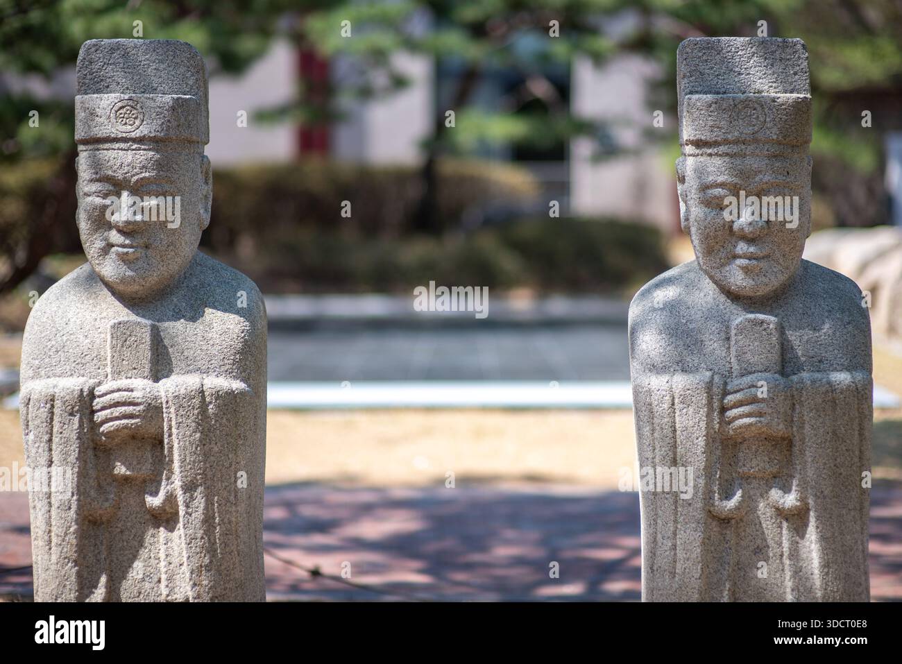 Two stone statues of ancient Korean scholars in traditional attire ...
