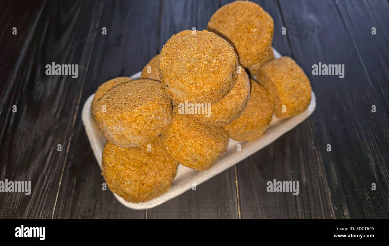 Freshly frozen breaded fish cakes. Round, semi-finished products, ready ...