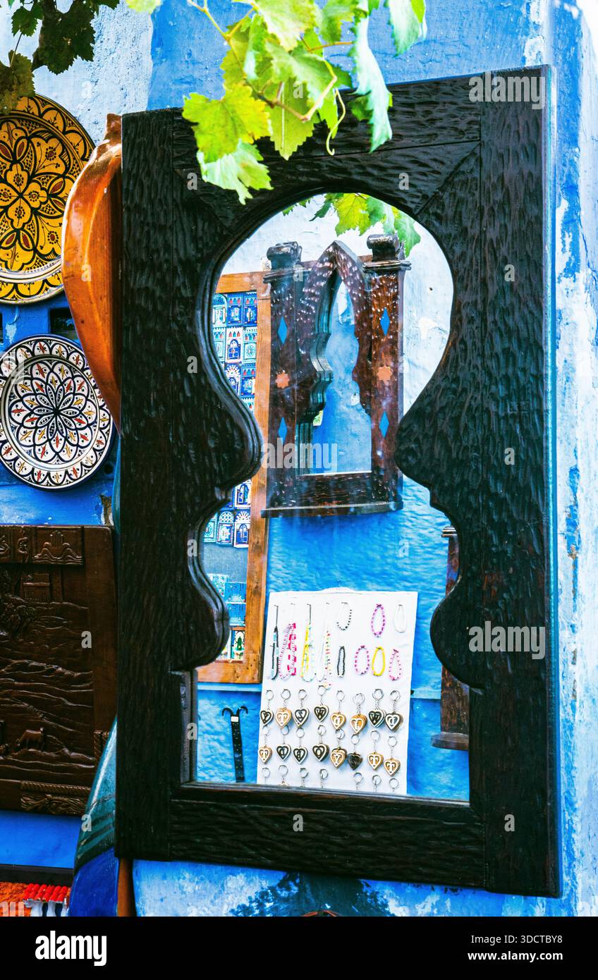 A traditionally carved mirror reflects architectural patterns and ...