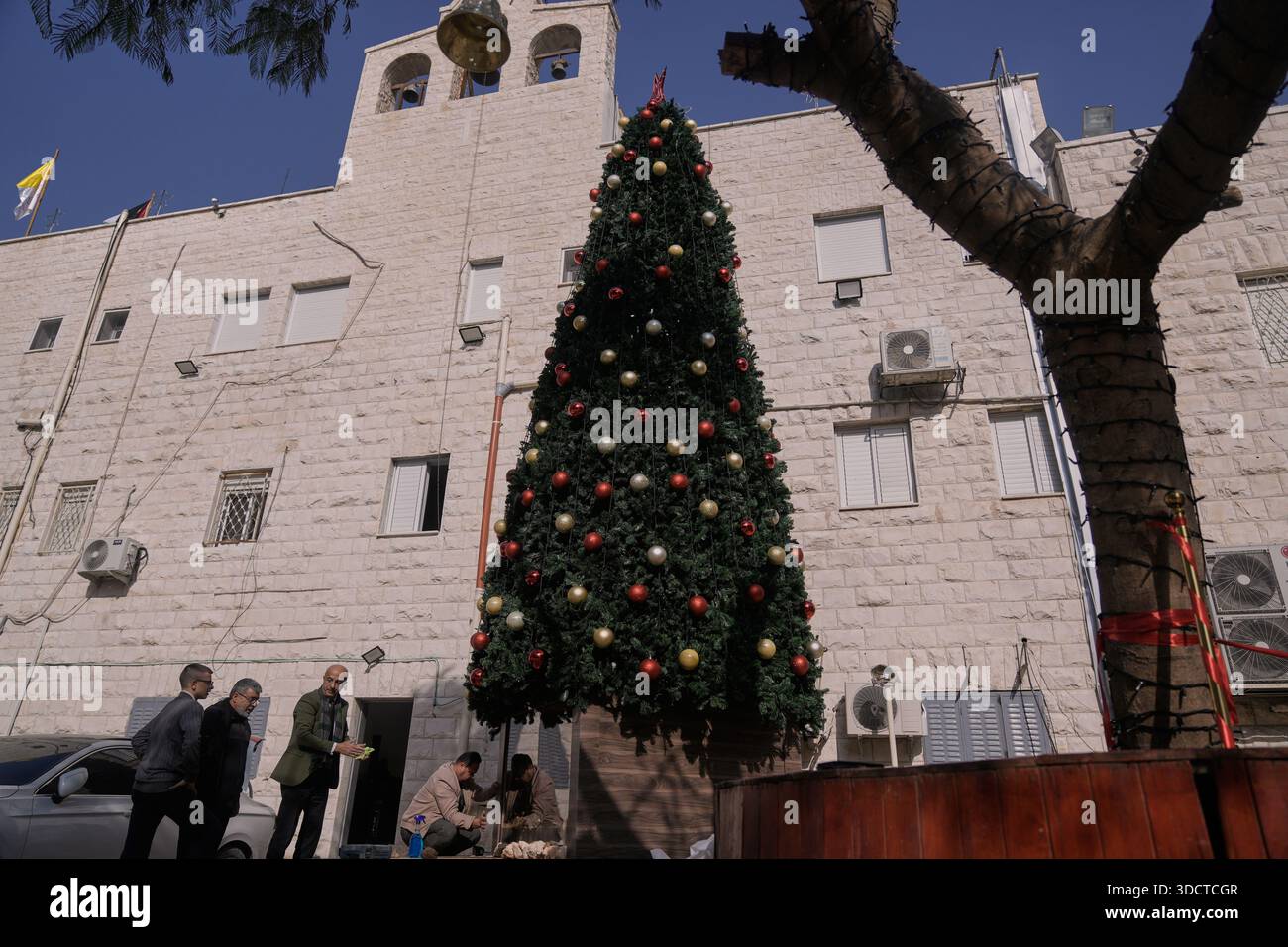 Palestinian parishioners check a recently installed Christmas tree ...