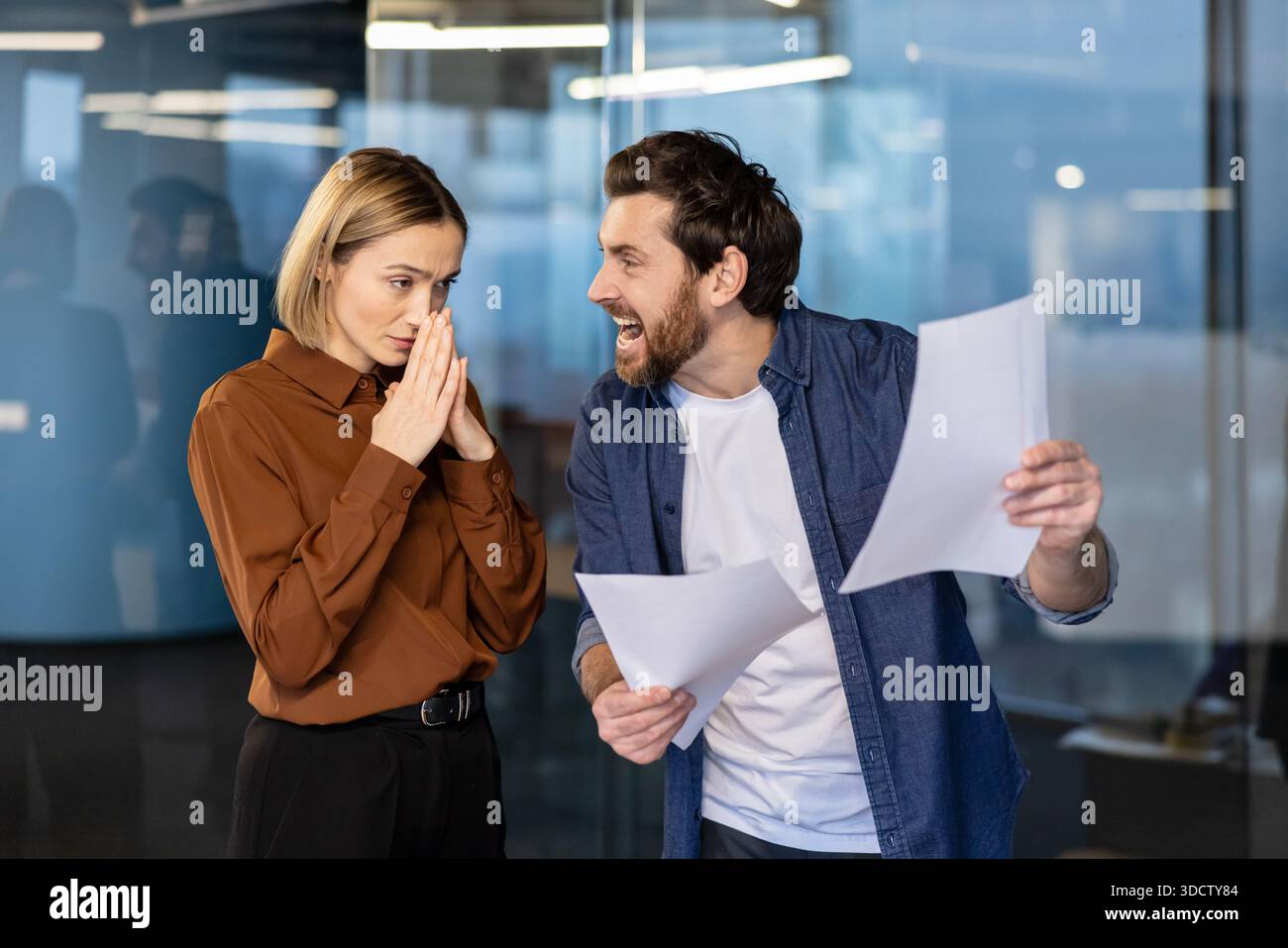 Angry male boss yelling at a stressed female employee holding her hands ...