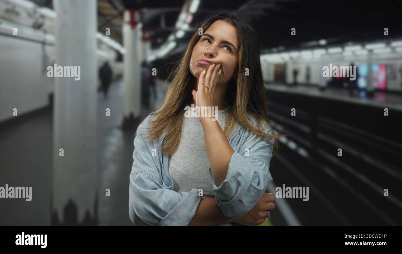 Teenage woman touching cheek and showing middle finger on a subway ...