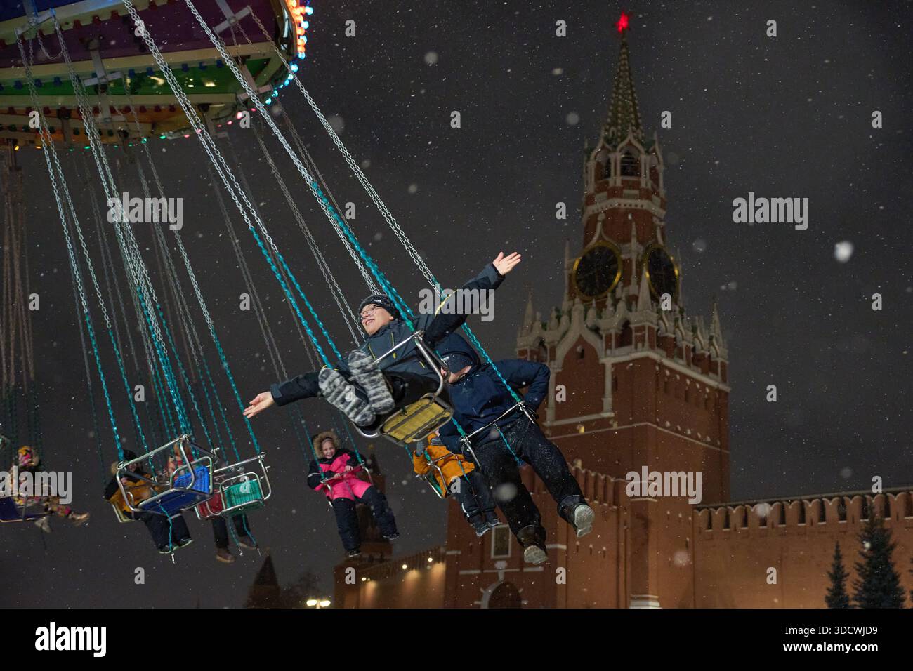 Children ride a carousel at the Christmas fair decorated for Christmas ...