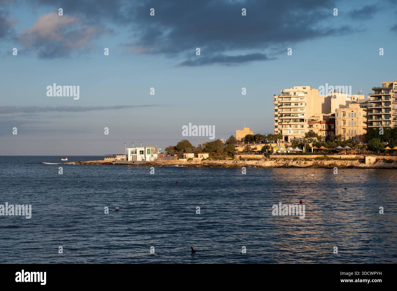 Saint Julians Bay and Spinola Bay at dusk with colorful sky reflections ...