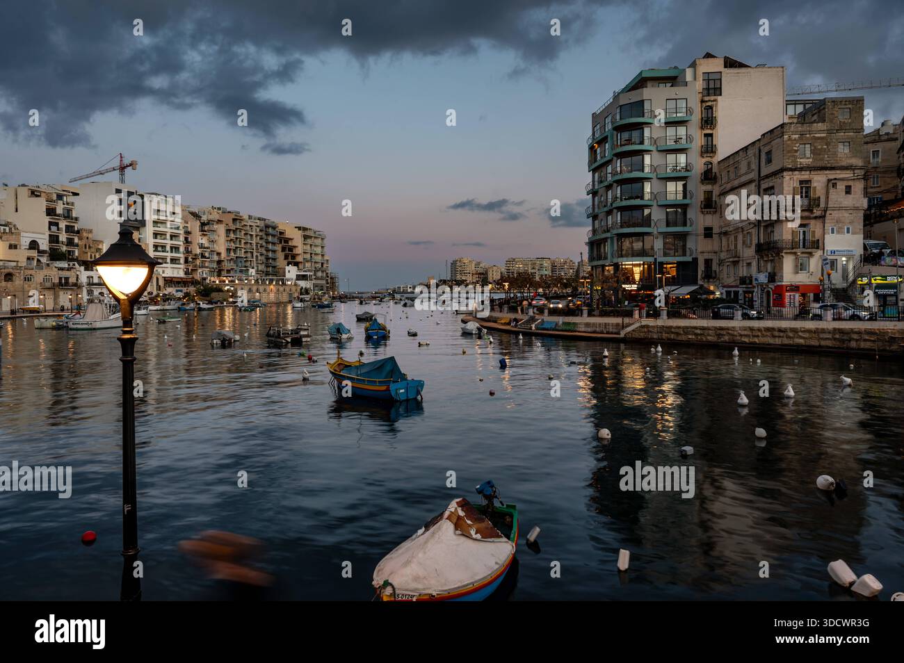Saint Julians Bay and Spinola Bay at dusk with colorful sky reflections ...