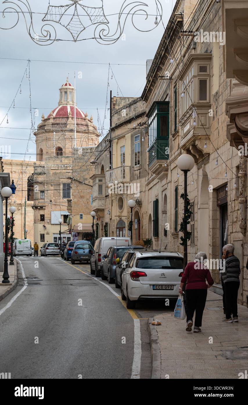 Elderly local residents walking through a narrow and winding street in ...