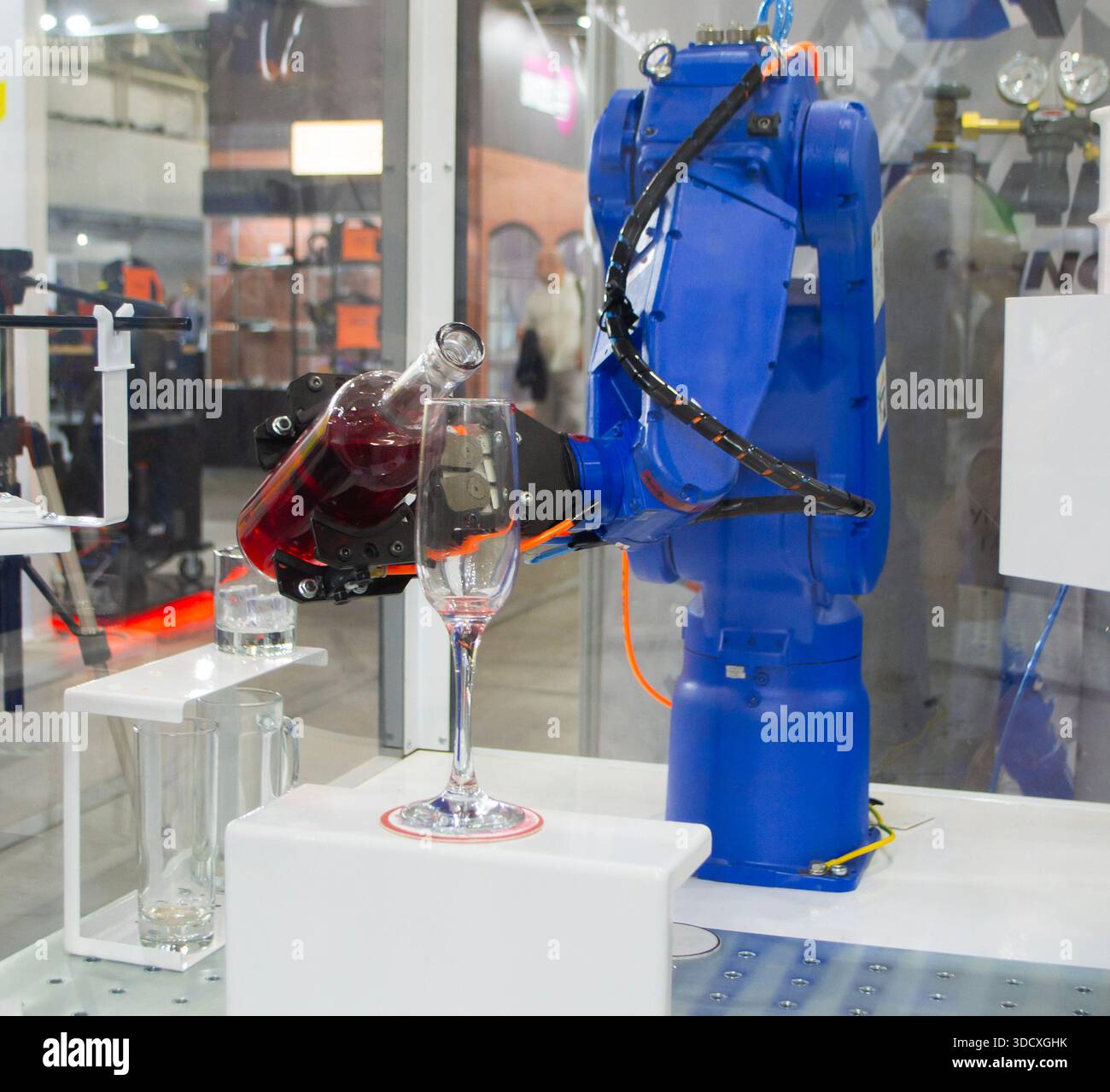 Robotic manipulators. Robot pouring liquid drink from bottle into glass ...