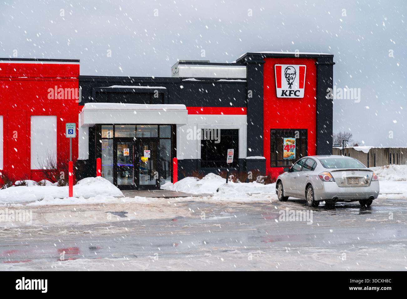 Rome, NY - Dec 17, 2025: KFC storefront with a winter snowfall view, a ...