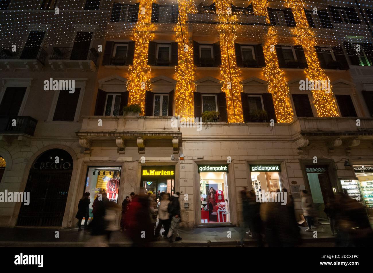 Shops on Via del Corso in Rome with Christmas lights on the facades of ...
