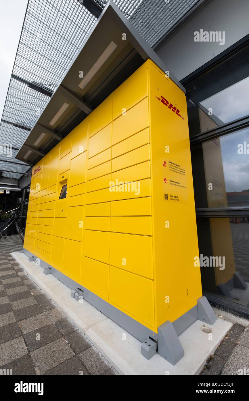 DHL Parcel machine and packing station with DHL logo against the facade ...