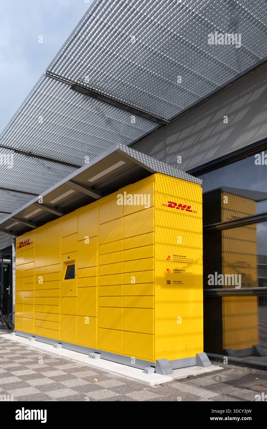 DHL Parcel machine and packing station with DHL logo against the facade ...