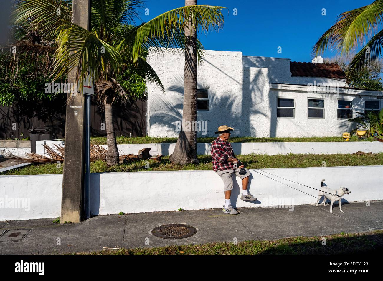 A man holds his dog as the motorcade for President Donald Trump rolls ...