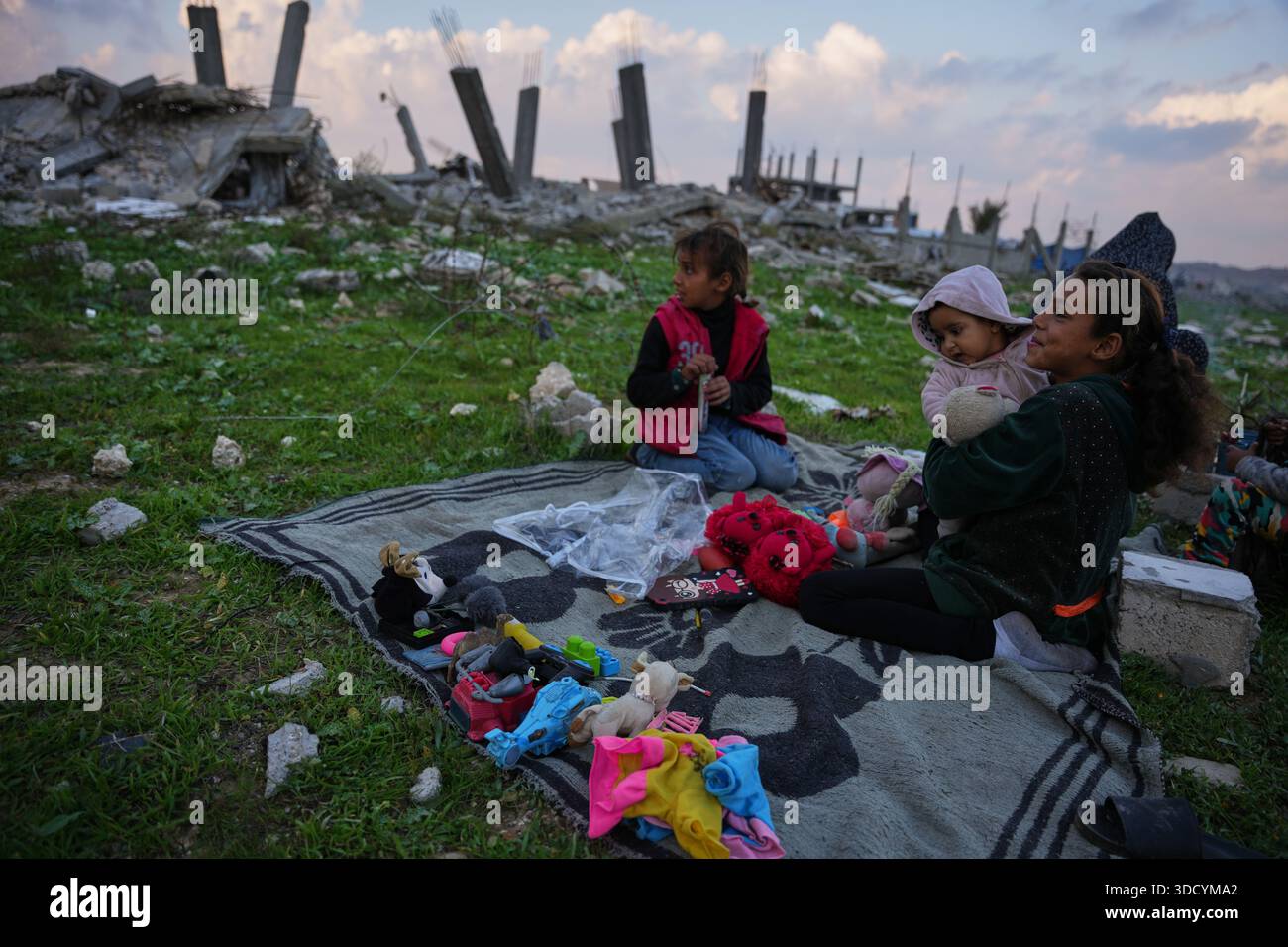Members of the Abu Rukba family sit together near destroyed buildings ...