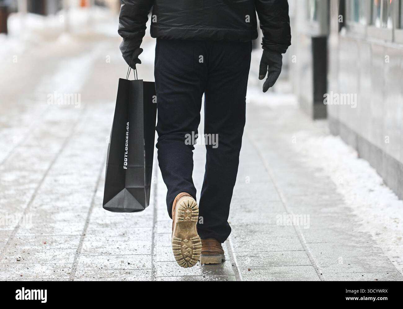 A person carries a Foot Locker shopping bag along a street on Boxing ...