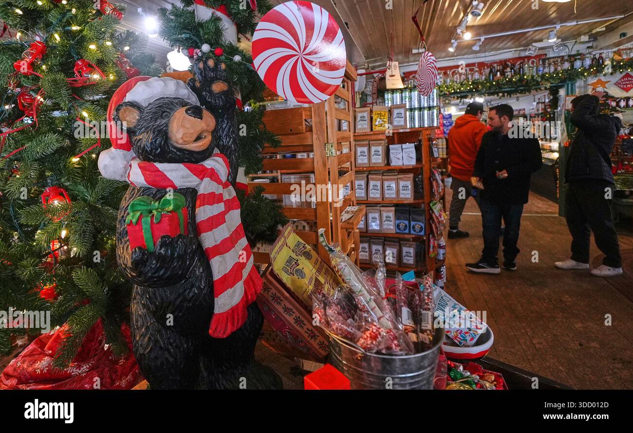 Post-holiday shoppers pass a Christmas tree and festive display at ...