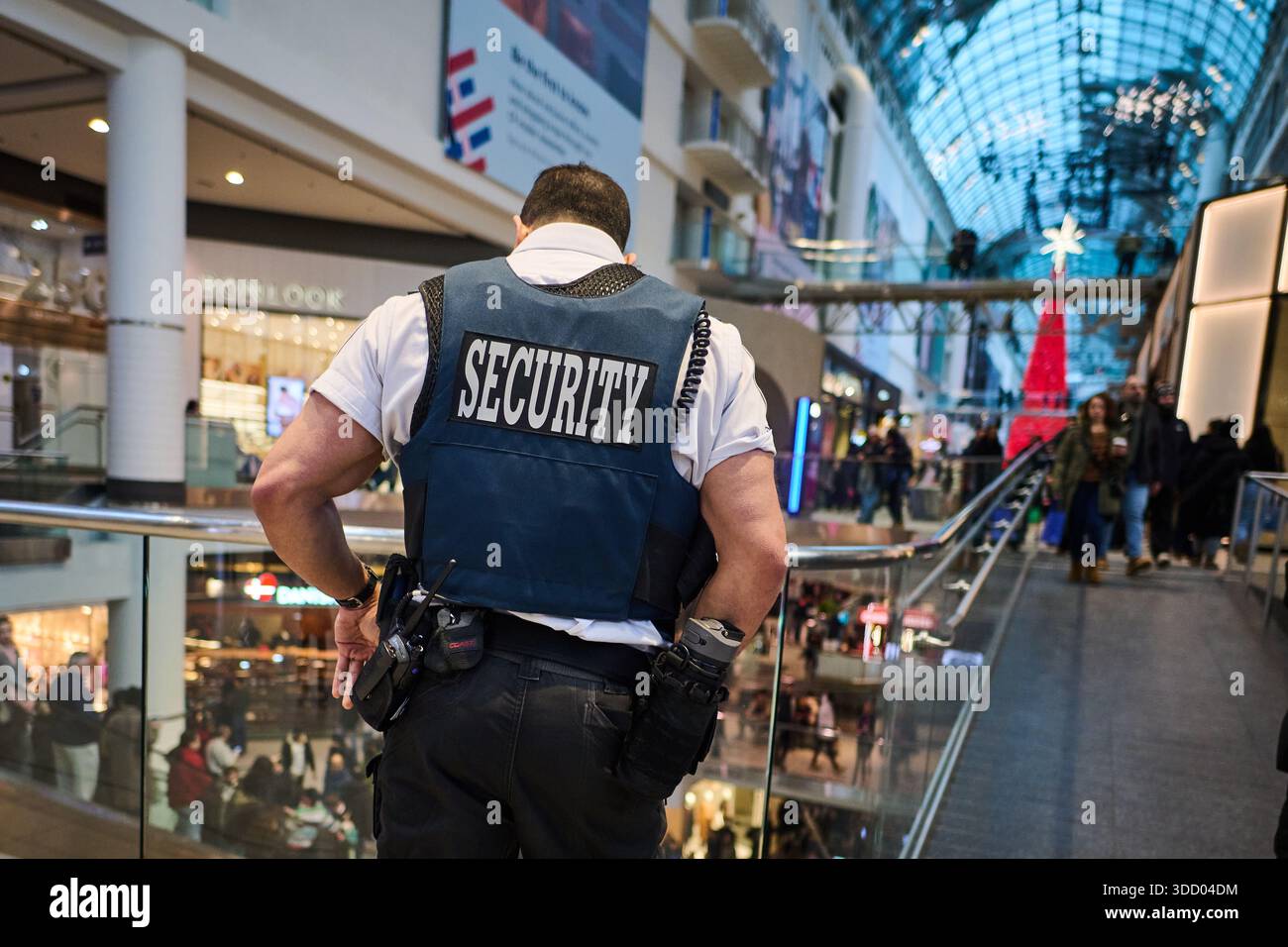 A security guard looks on as shoppers browse items for sale at Eaton ...