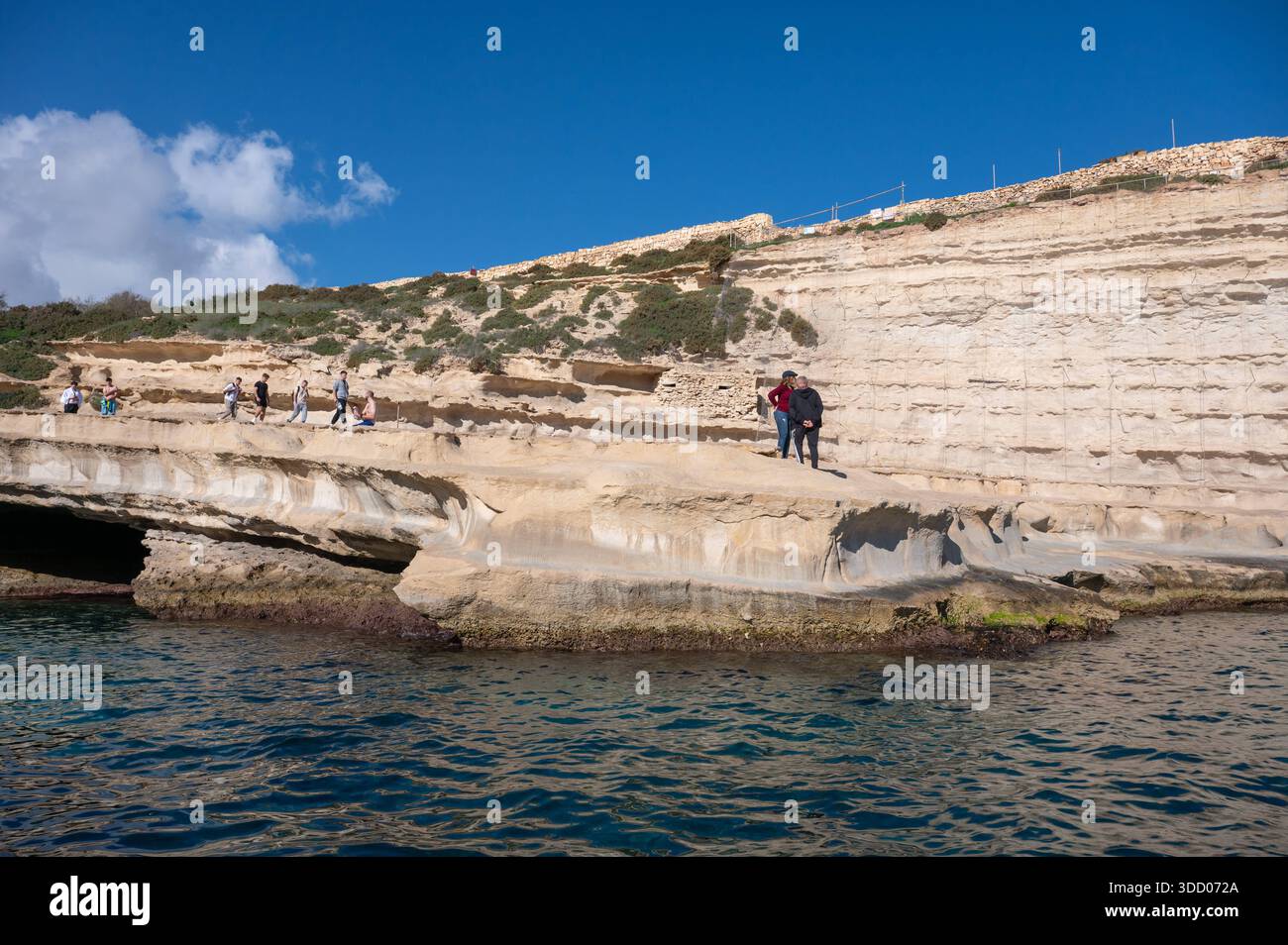 Young people sunbathing and wading at Saint Peters Pool, enjoying sunny ...
