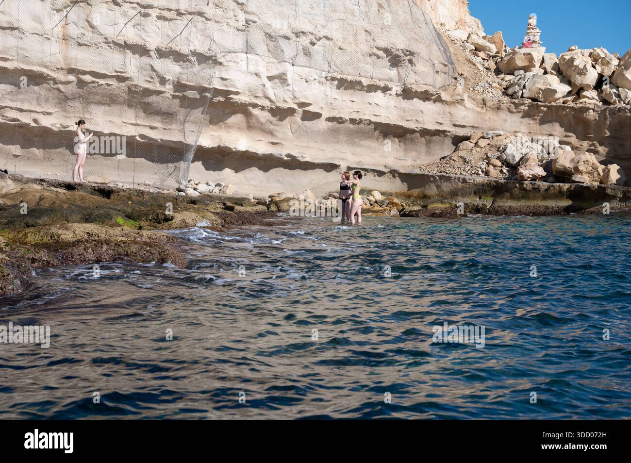 Young people sunbathing and wading at Saint Peters Pool, enjoying sunny ...