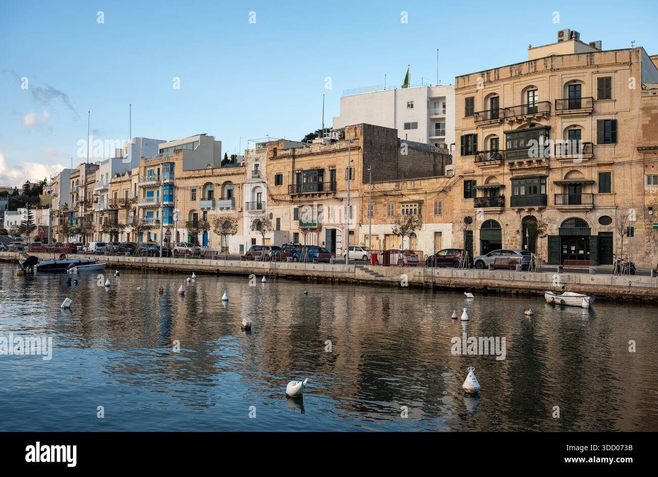 Kalkara harbor at sunset with colorful reflections of boats on the ...