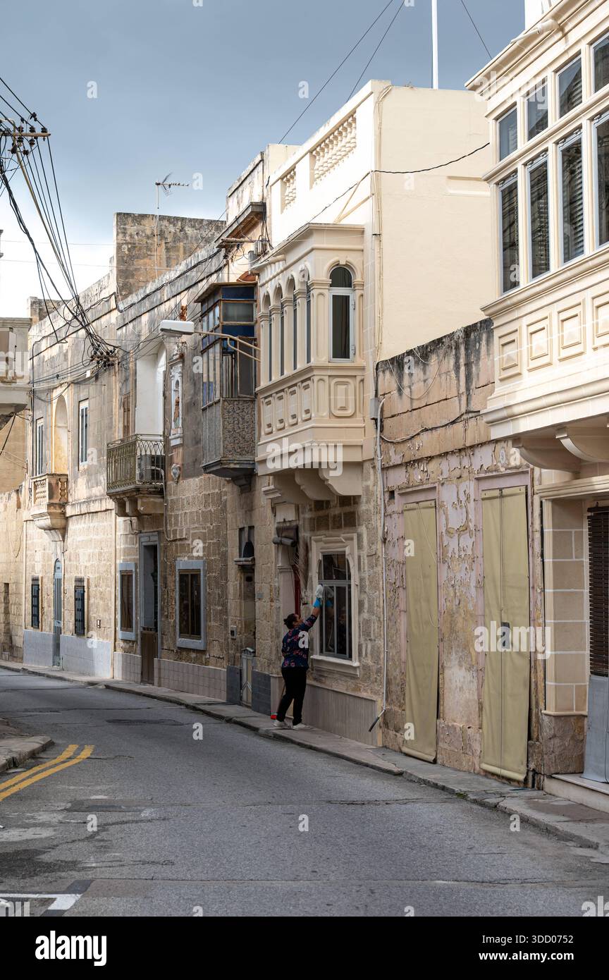 Narrow streets lined with simple houses featuring colorful wooden doors ...