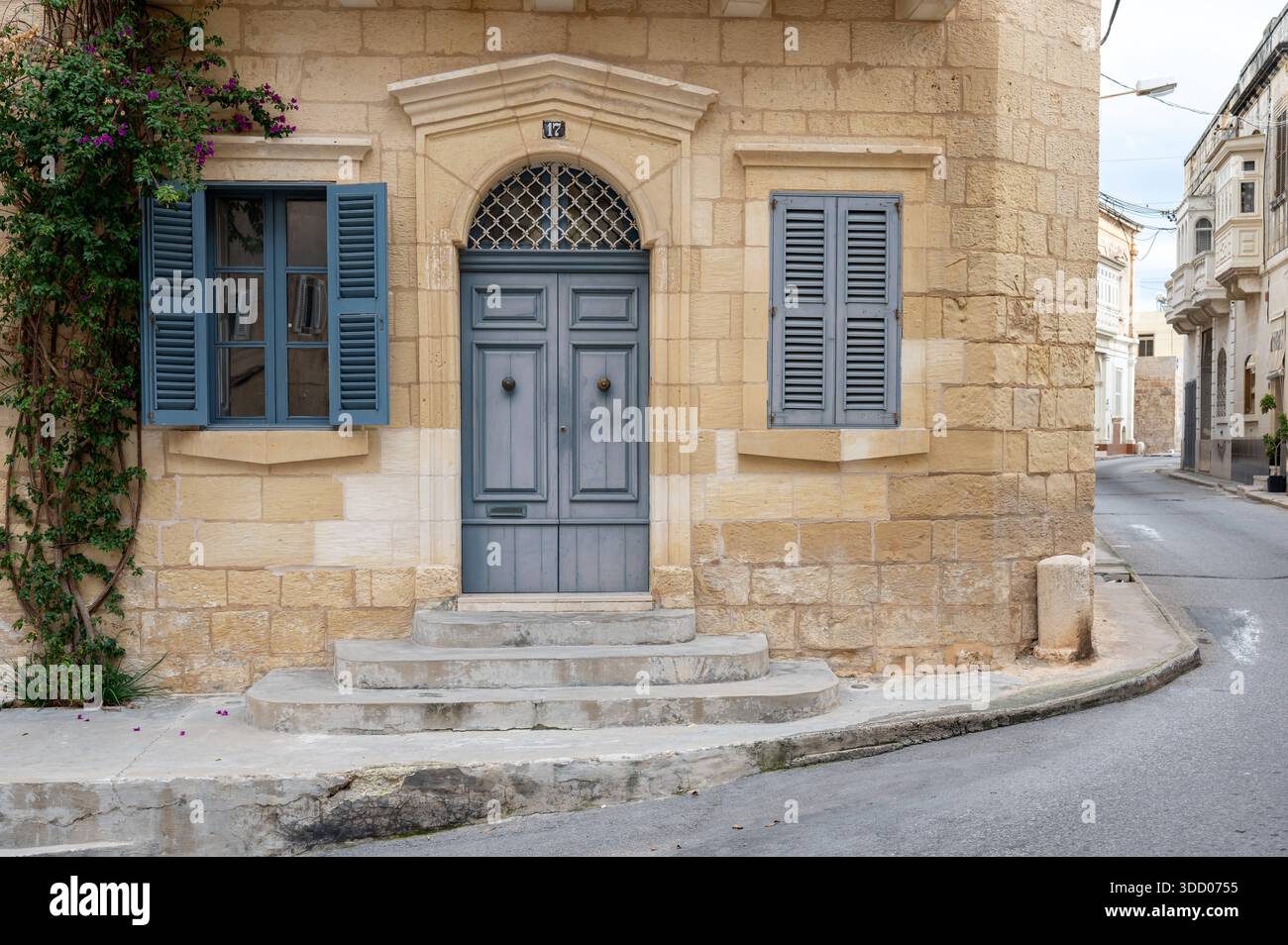 Narrow streets lined with simple houses featuring colorful wooden doors ...