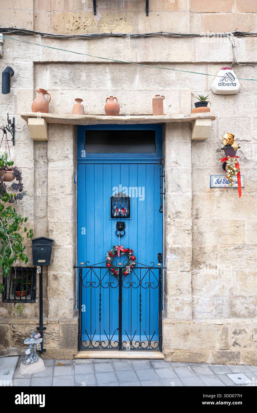 Narrow streets lined with simple houses featuring colorful wooden doors ...