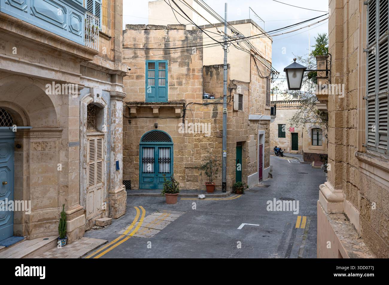 Narrow streets lined with simple houses featuring colorful wooden doors ...