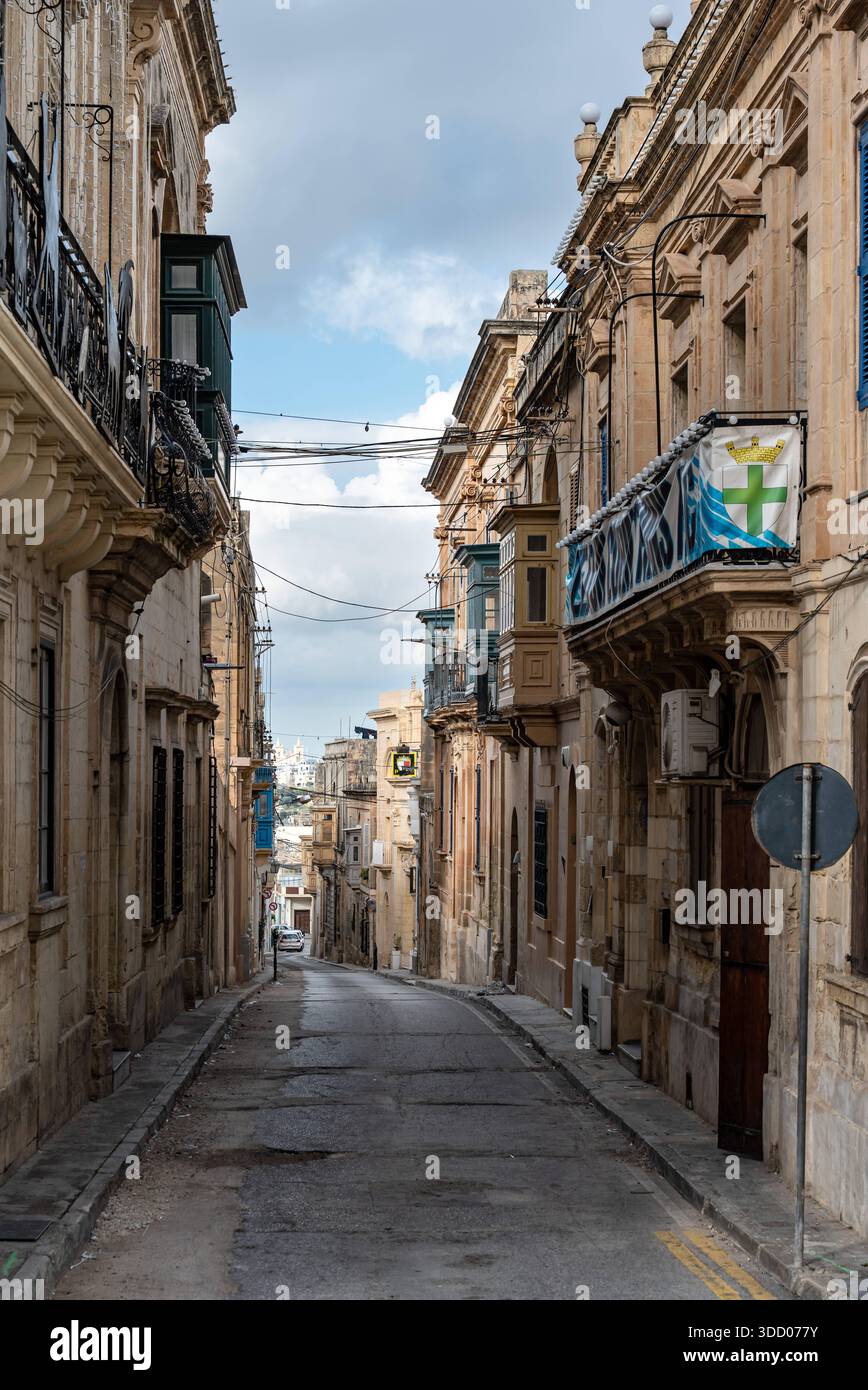 Narrow streets lined with simple houses featuring colorful wooden doors ...