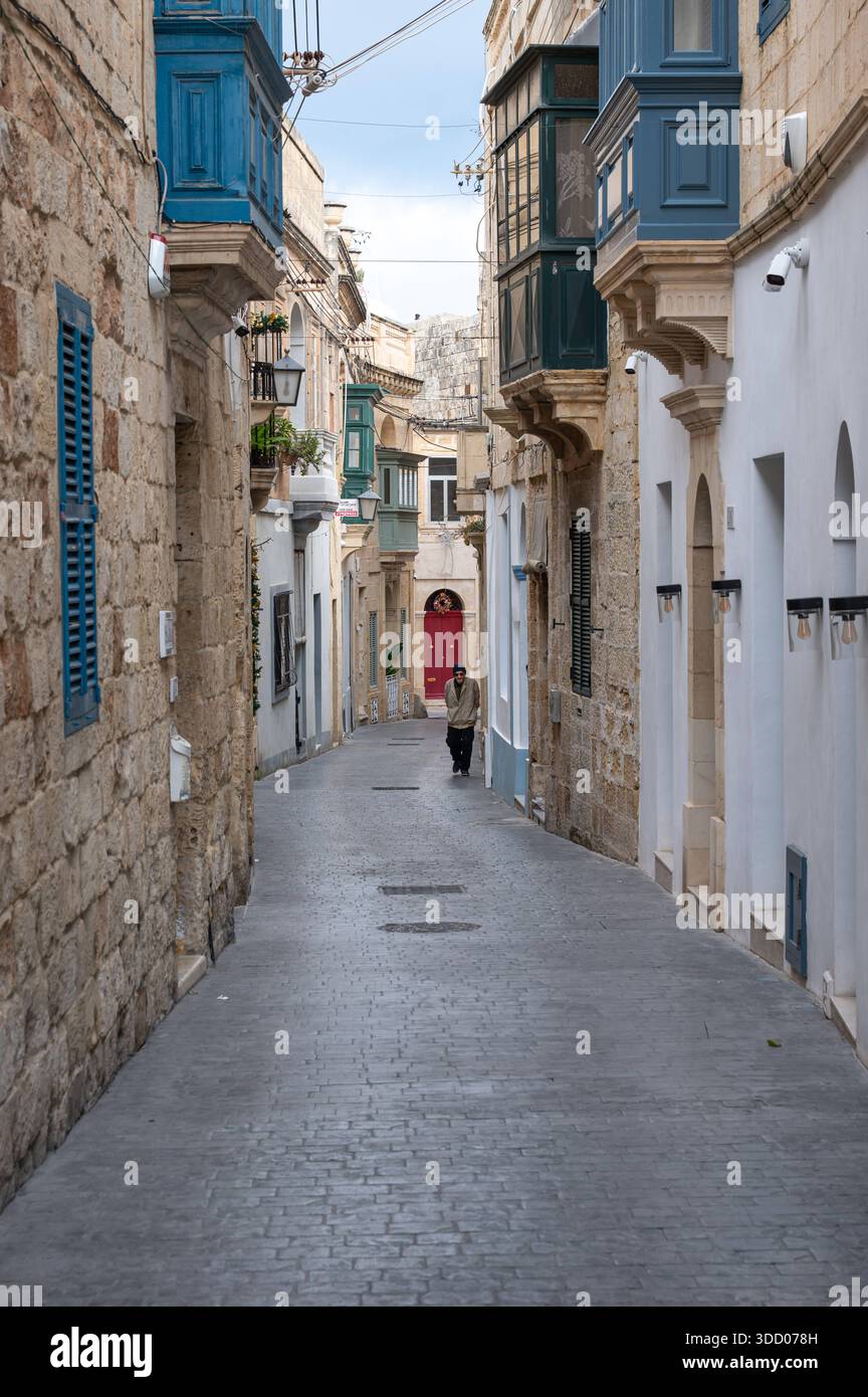 Narrow streets lined with simple houses featuring colorful wooden doors ...