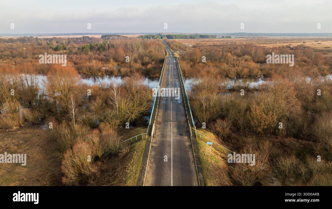 Aerial view of a long straight bridge in rural Belarus during thaw ...