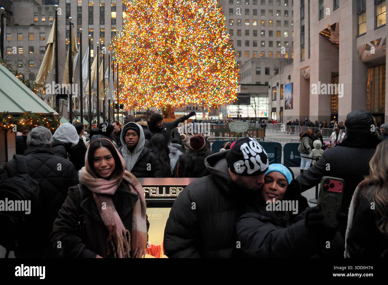 People take photos in front of the Rockefeller Center Christmas tree in ...