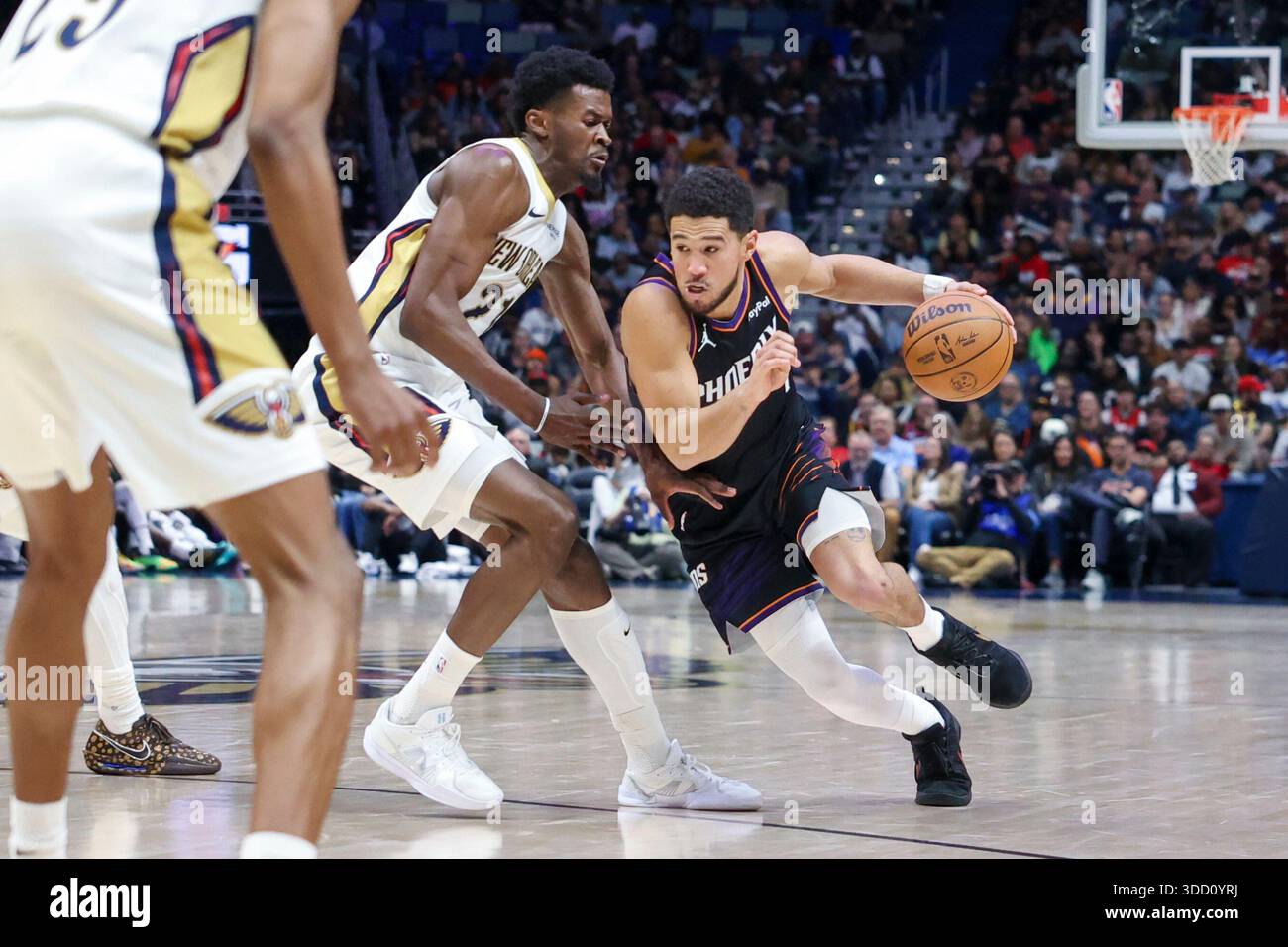 Phoenix Suns guard Devin Booker, right, tries to drive past New Orleans ...