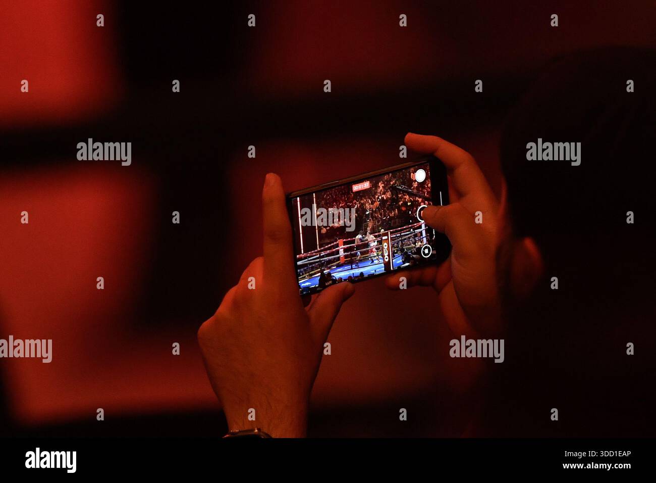 A spectator films on mobile phone as Japan's Taiga Imanaga fights ...