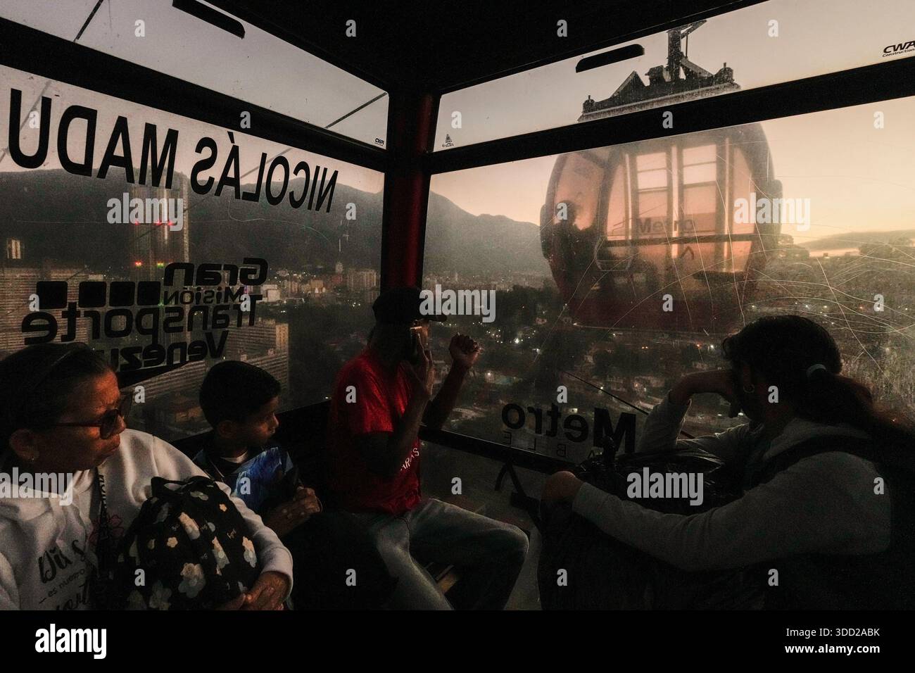 People ride a cable car toward the San Agustin neighborhood of Caracas ...
