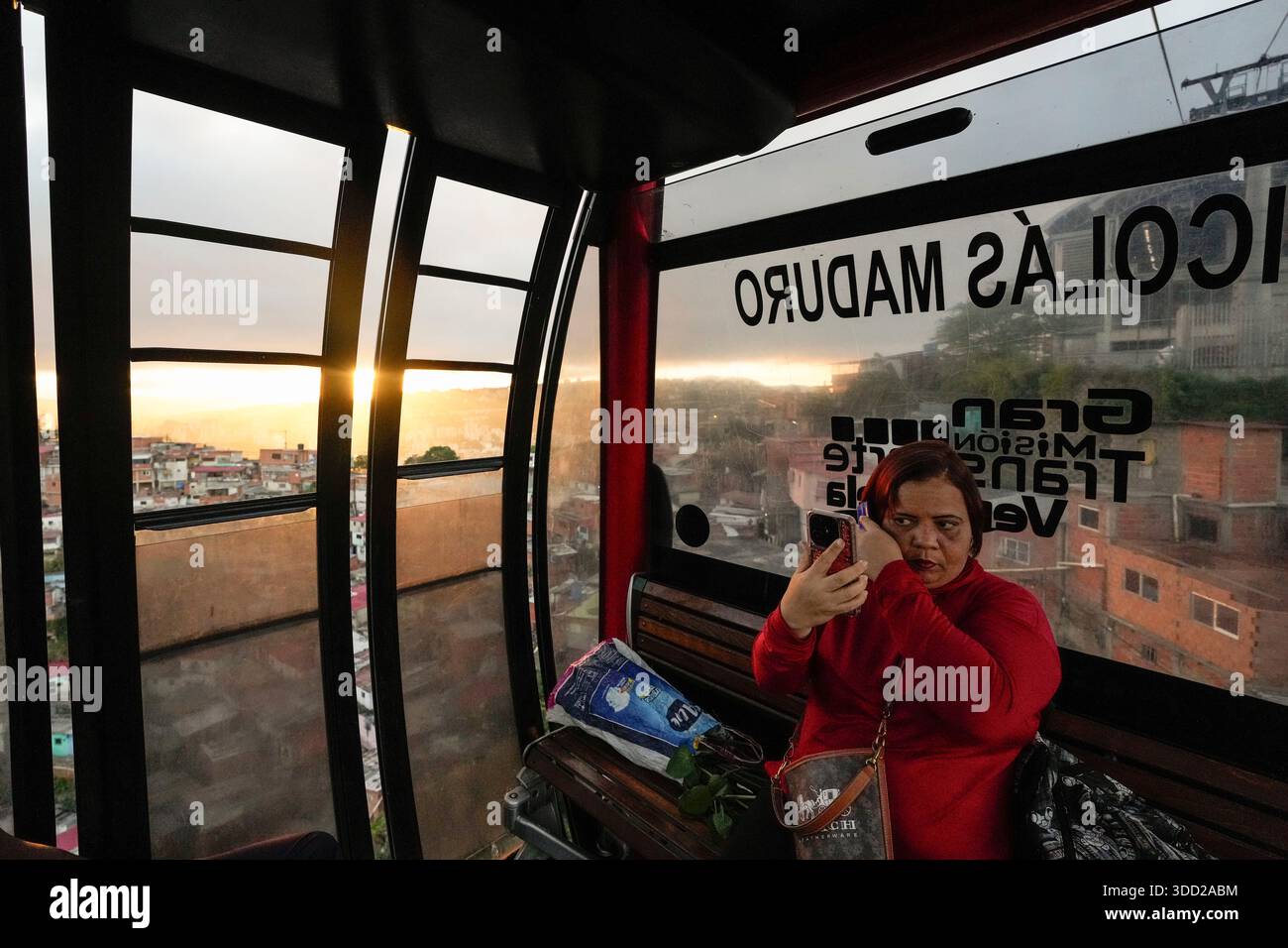 A woman puts on makeup as she rides a cable car toward the San Agustin ...
