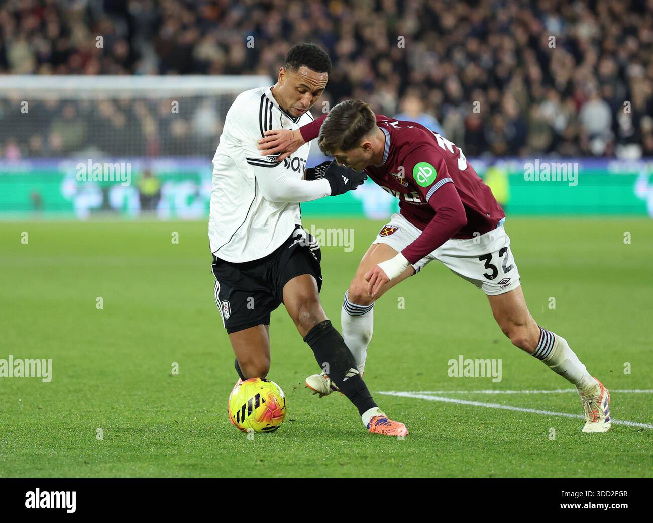 Fulham's Kenny Tete and West Ham's Freddie Potts battle for the ball ...
