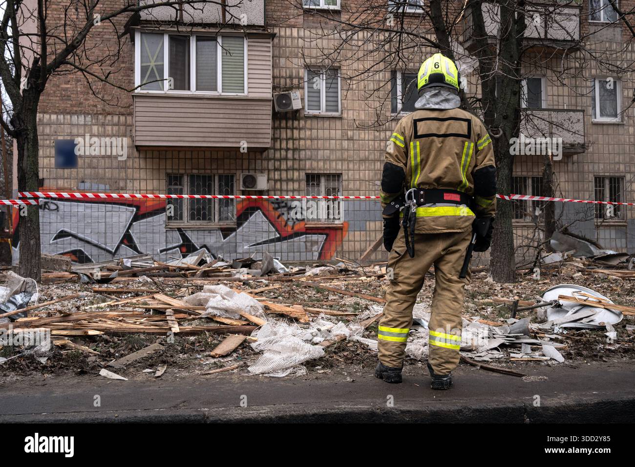 A rescuer stands at a barricade tape outside an apartment block in the ...
