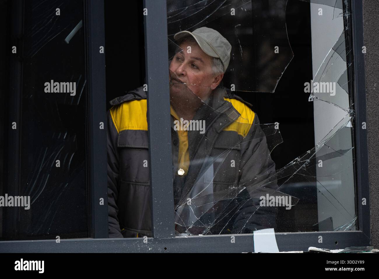 A man examines a shattered window in an apartment block in the ...