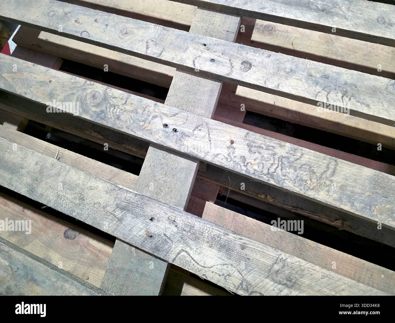 A wood pallet is shown from above with wooden slats aligned in rows and ...