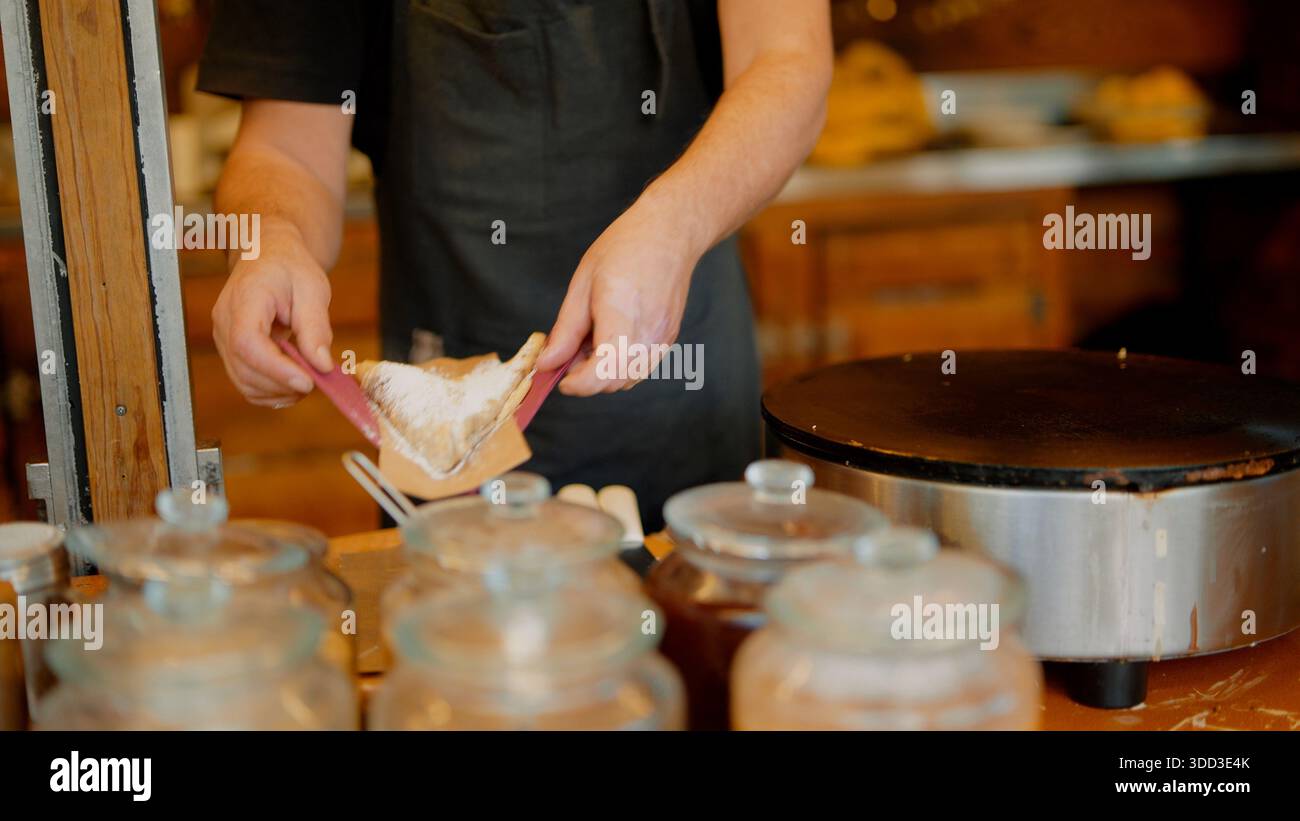 Busy street food vendor preparing warm crepes for takeaway Stock Photo ...