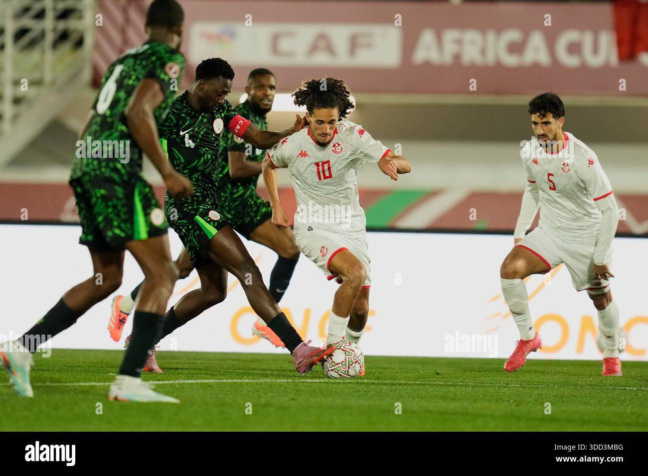 Tunisia's Hannibal Mejbri, center, is challenged by Nigeria's Wilfred ...