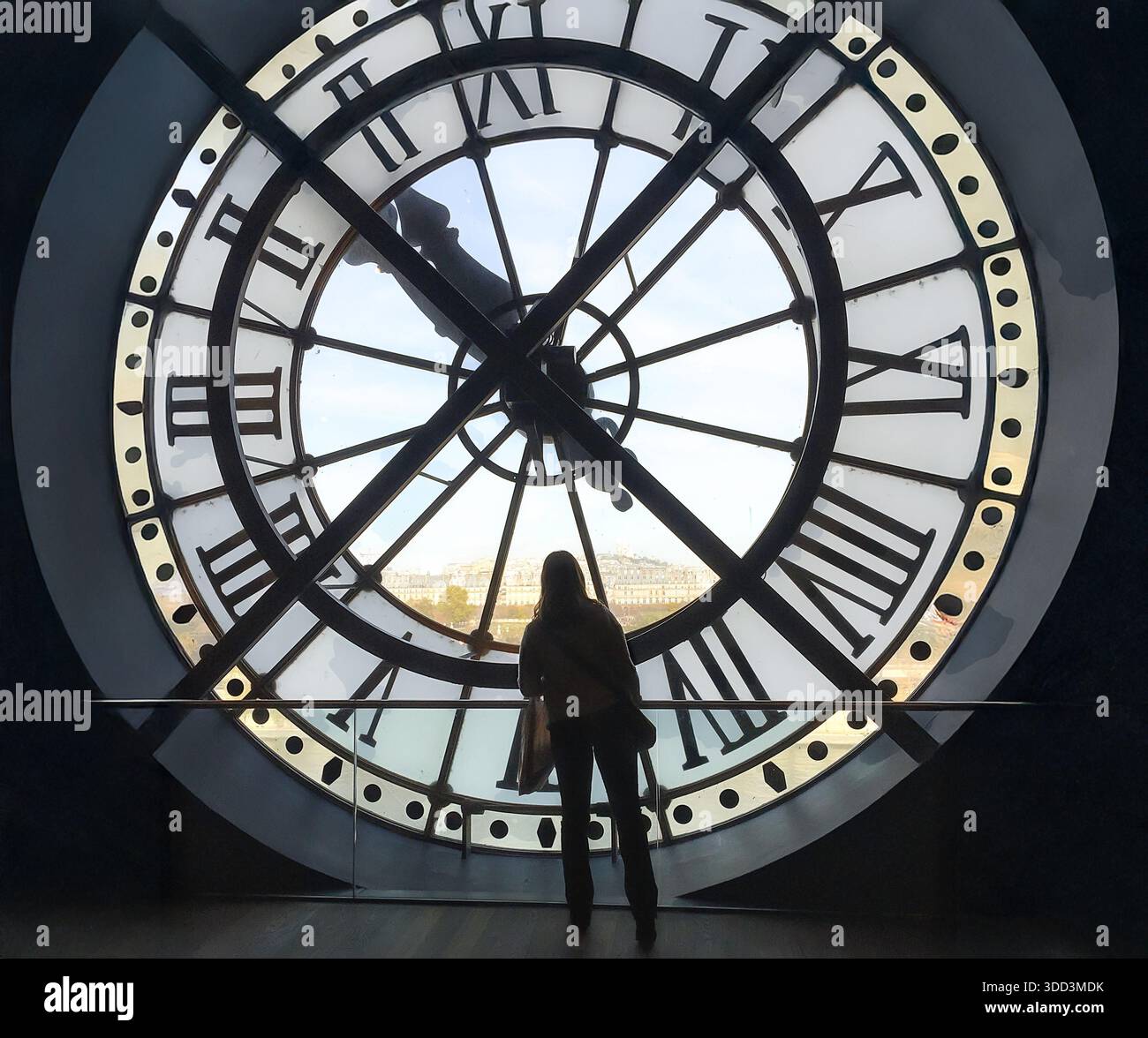 Woman standing inside a large clock face with Roman numerals, viewed ...