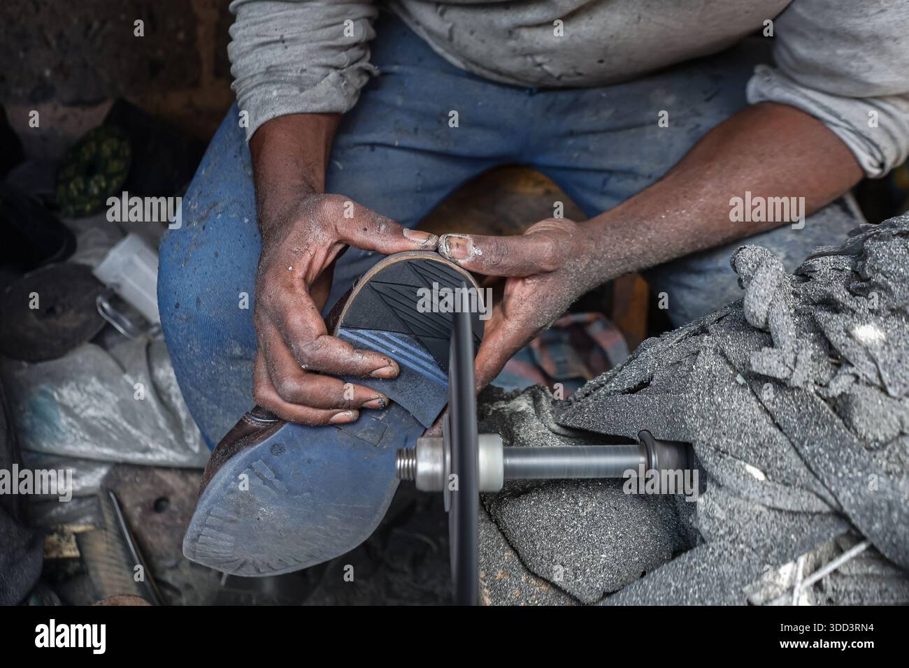 A cobbler at the Gikomba market carving deeper tread patterns on a ...