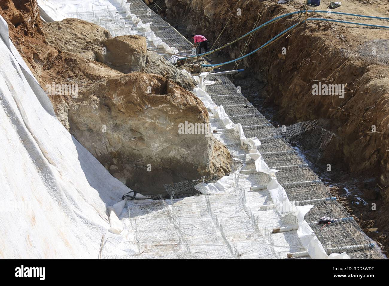 Construction site trench excavation with large rock soil and geotextile ...