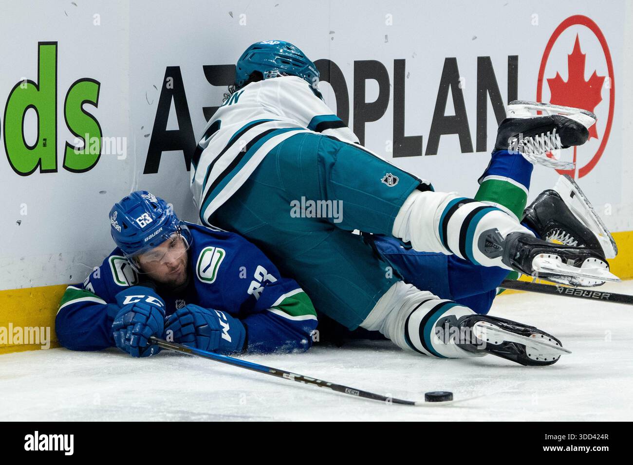 Vancouver Canucks' Max Sasson (63) passes the puck after being hit by ...